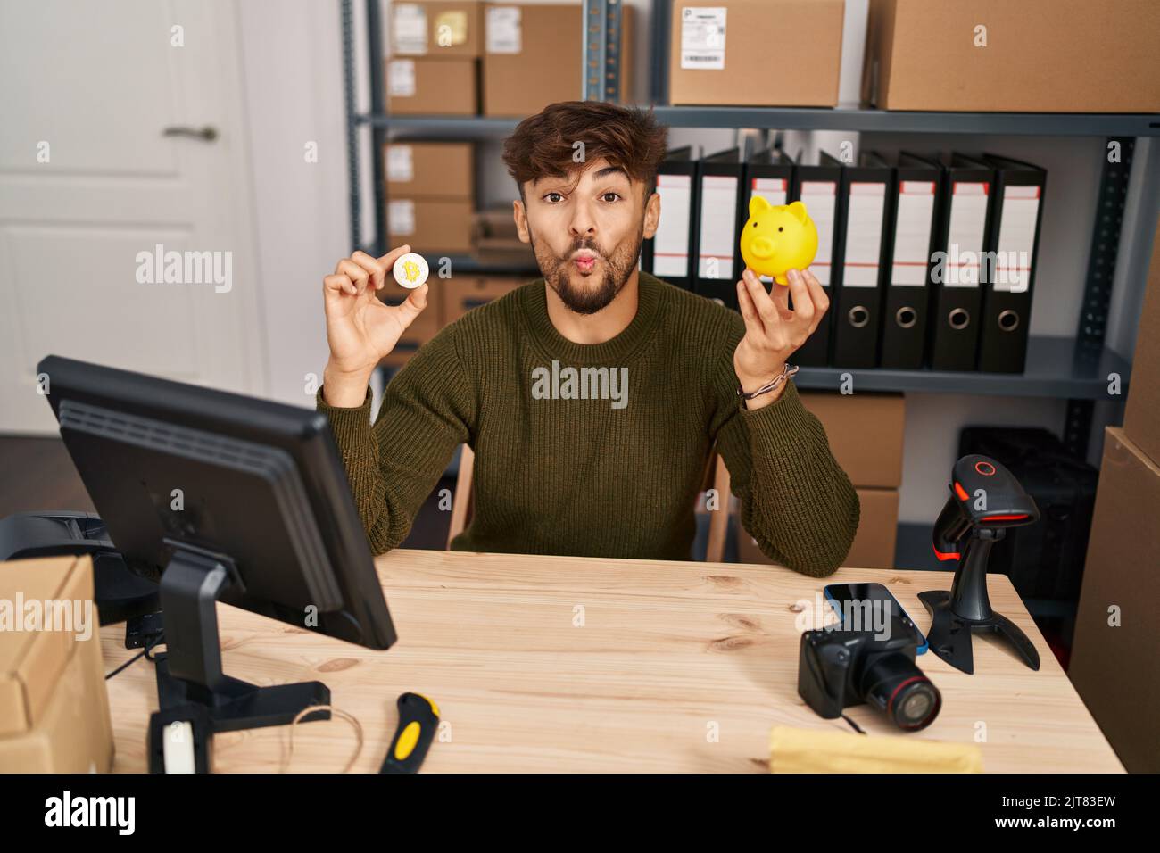 Arab man with beard working at small business ecommerce holding bitcoin ...