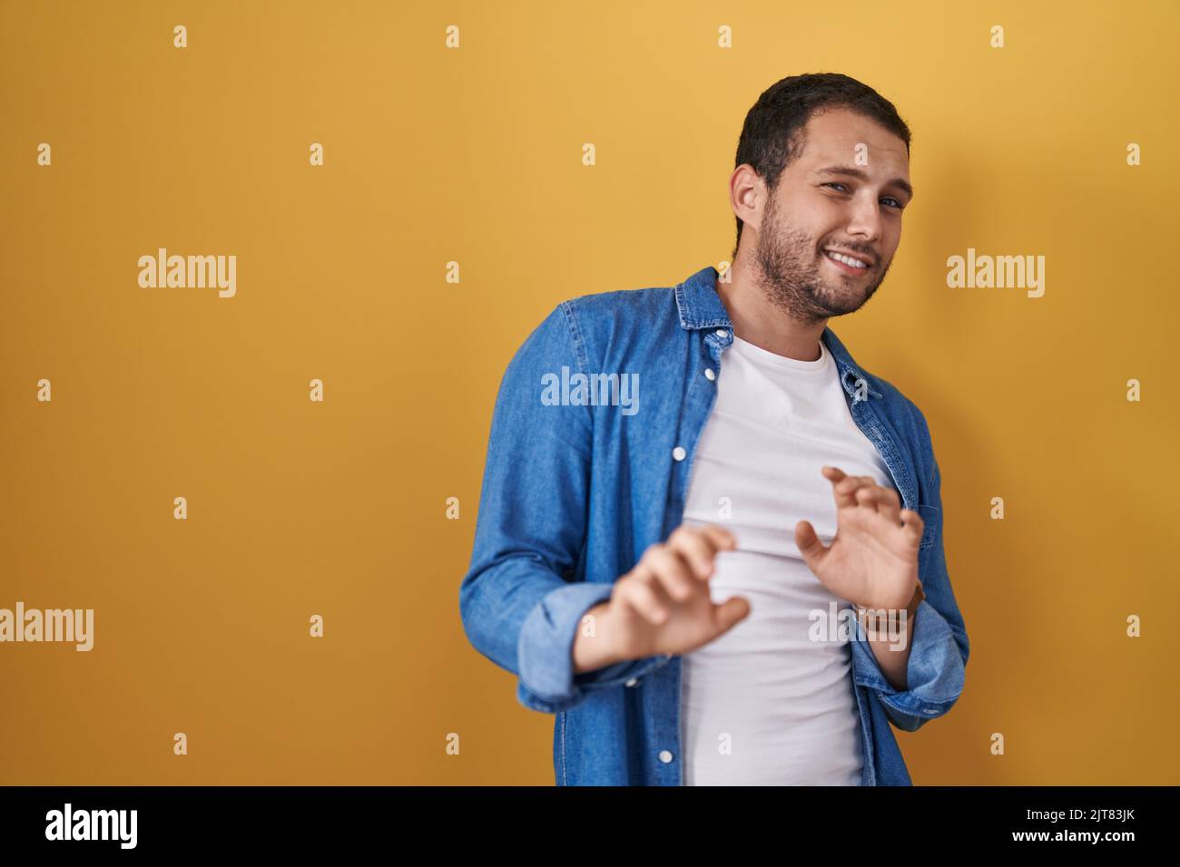 Hispanic man standing over yellow background disgusted expression ...