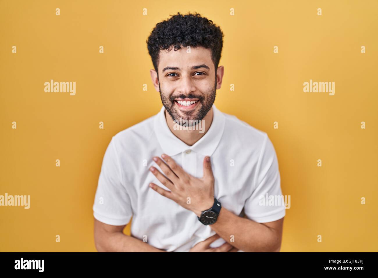 Arab man standing over yellow background smiling and laughing hard out ...