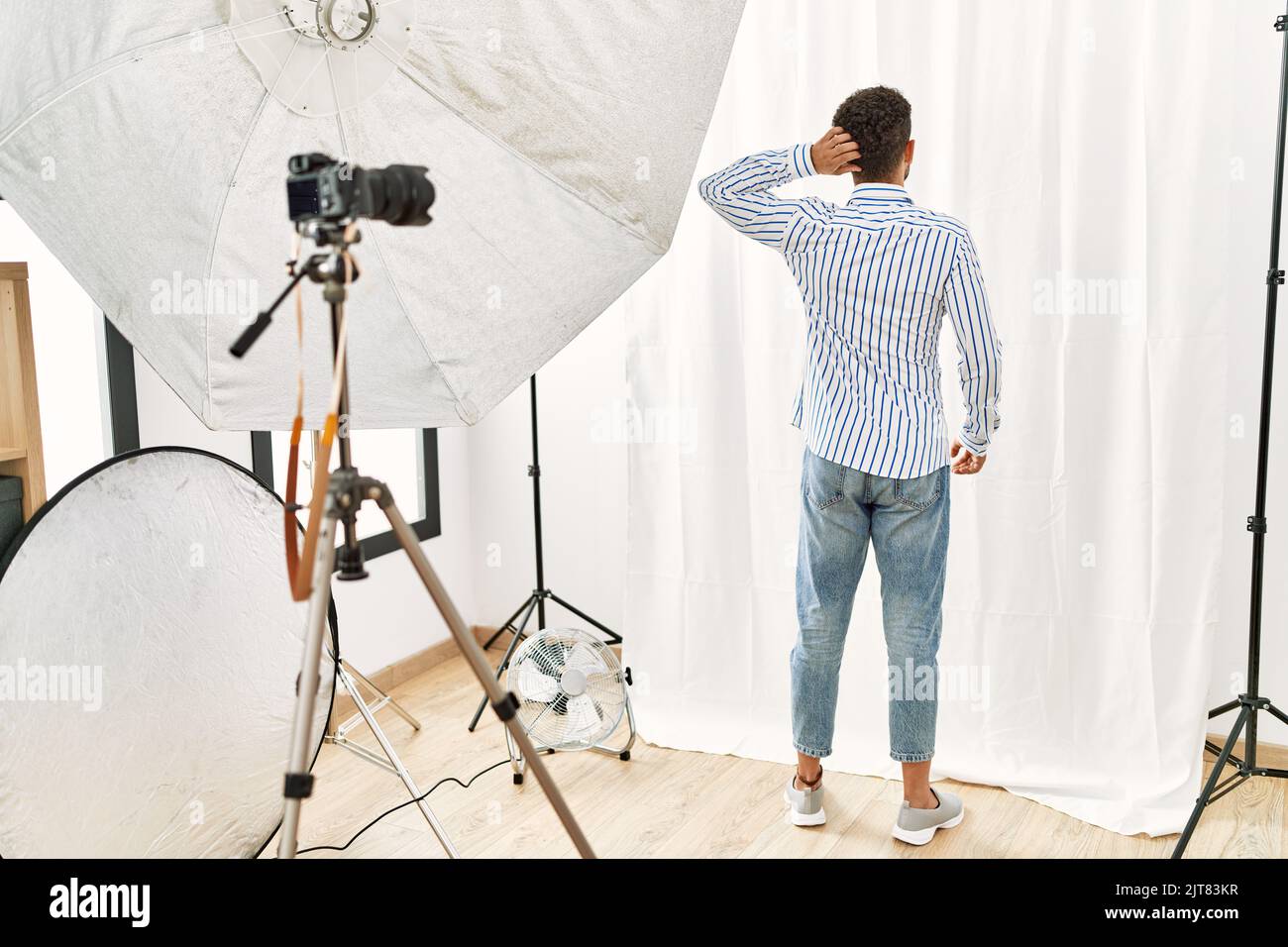 Arab young man posing as model at photography studio backwards thinking ...