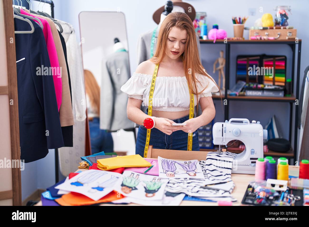 Young redhead woman tailor make photo by smartphone to clothing design ...