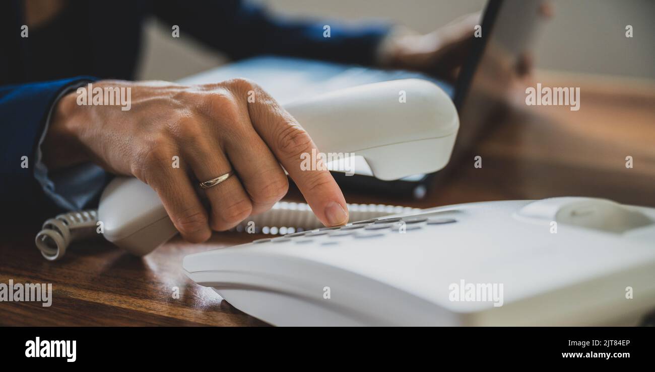 Low angle closeup view of caucasian female hand holding white landline ...