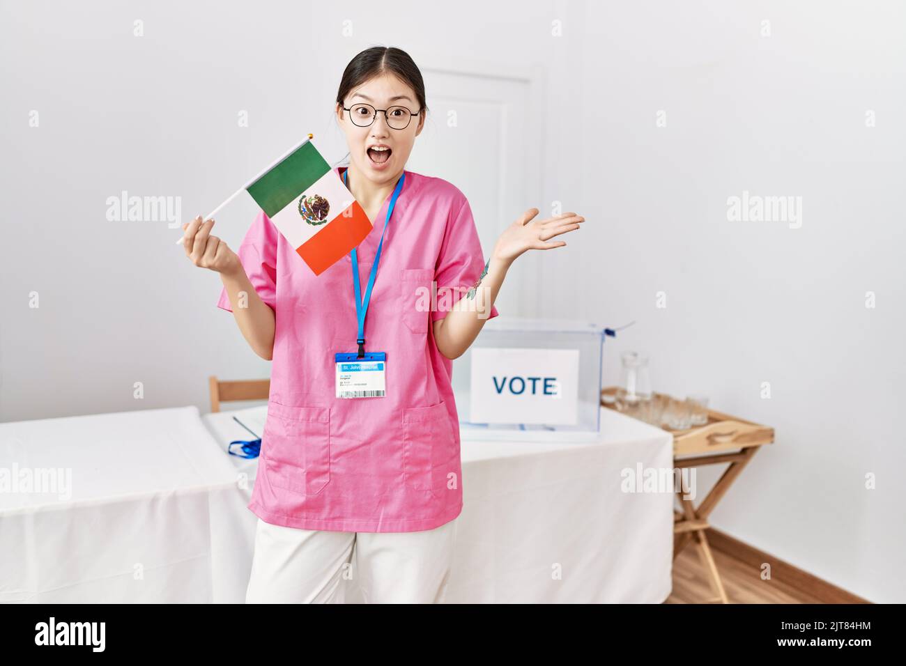Young asian nurse woman at political campaign election holding mexico ...