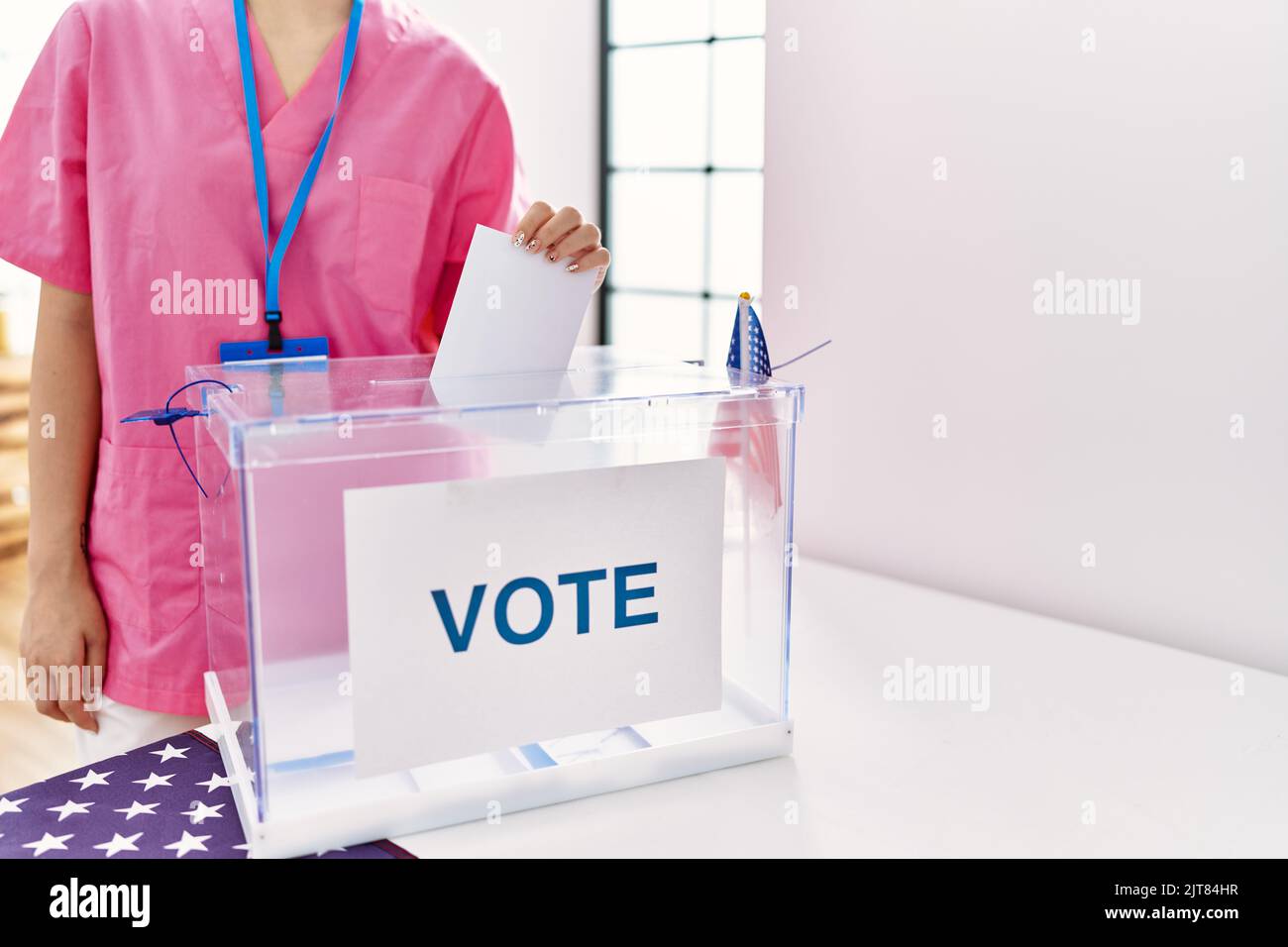 Young asian woman putting envelope into ballot at american election ...