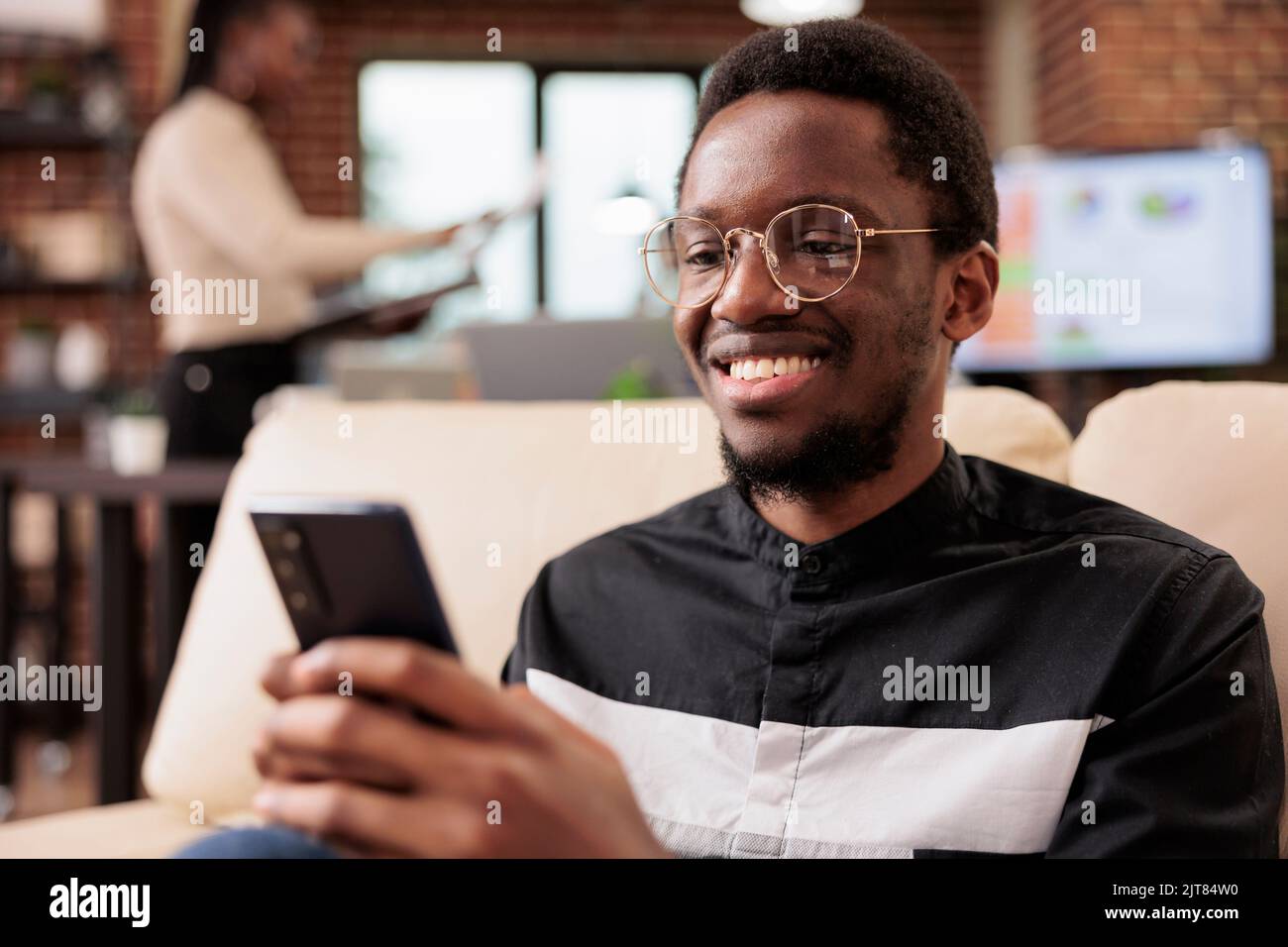 Male freelancer using mobile phone to browse internet website, creating ...