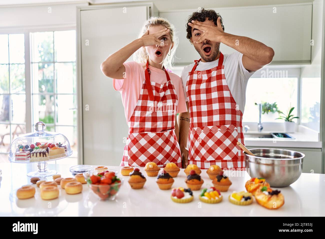 Couple of wife and husband cooking pastries at the kitchen peeking in ...