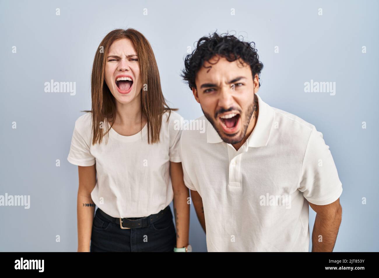 Young couple wearing casual clothes standing together angry and mad ...