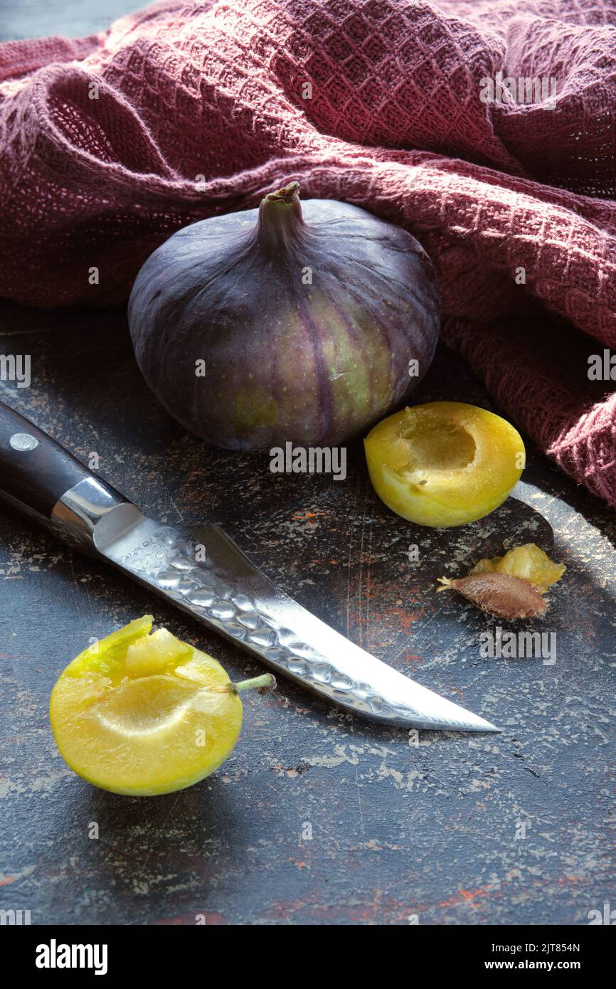 Closeup on Autumn fruits, purple fig, yellow pear and yellow plums with ...