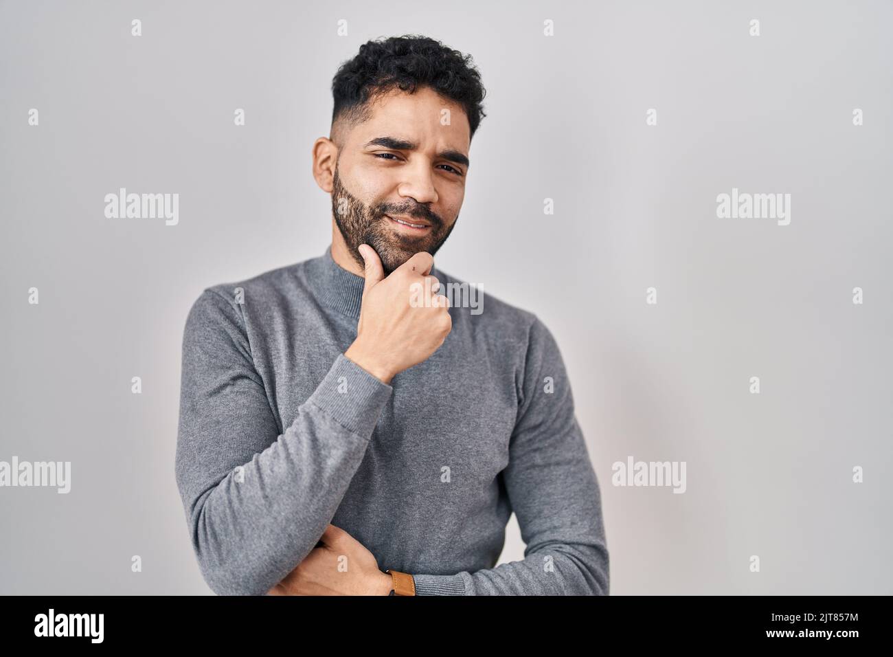 Hispanic man with beard standing over white background looking ...