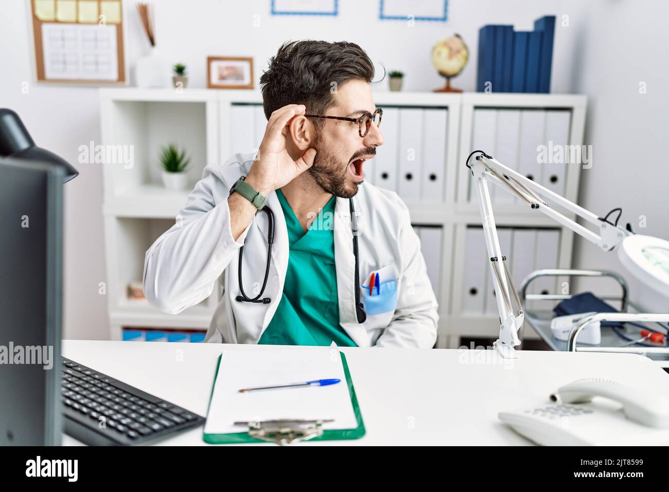 Young man with beard wearing doctor uniform and stethoscope at the ...