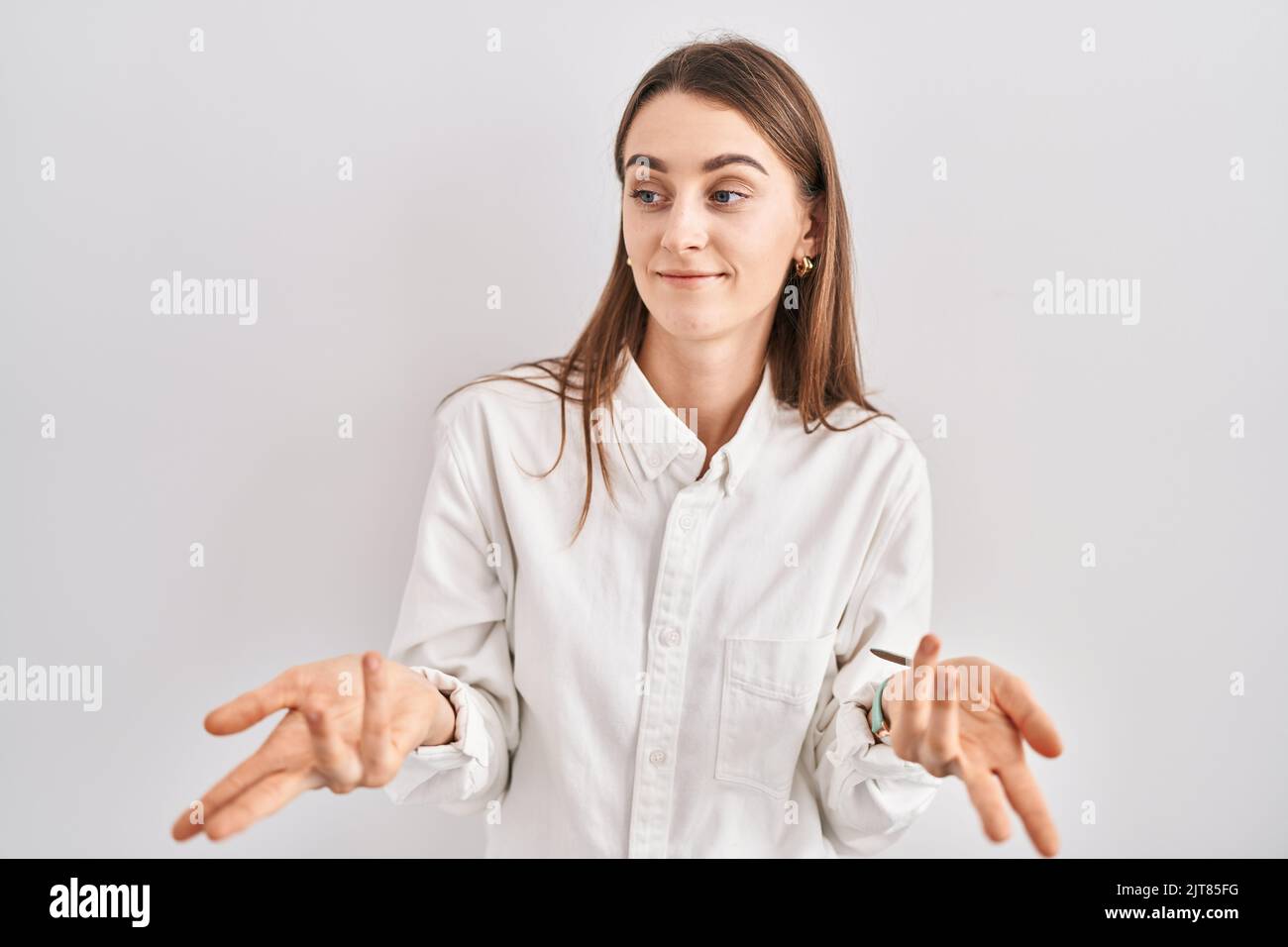 Young caucasian woman standing over isolated background clueless and ...