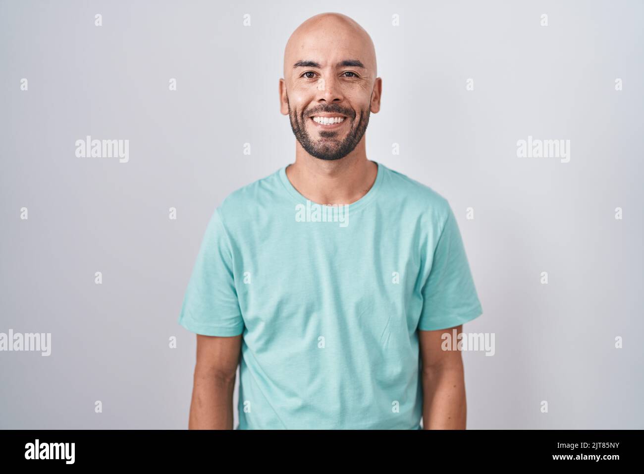 Middle age bald man standing over white background with a happy and ...