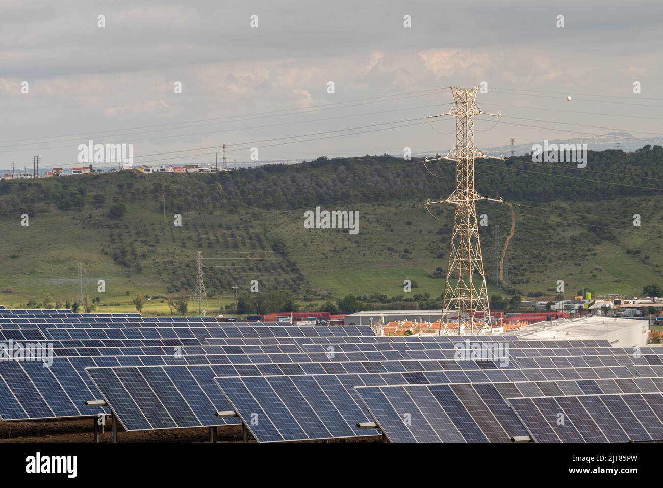 A Huge area with a Transmission tower and large solar panels with green ...