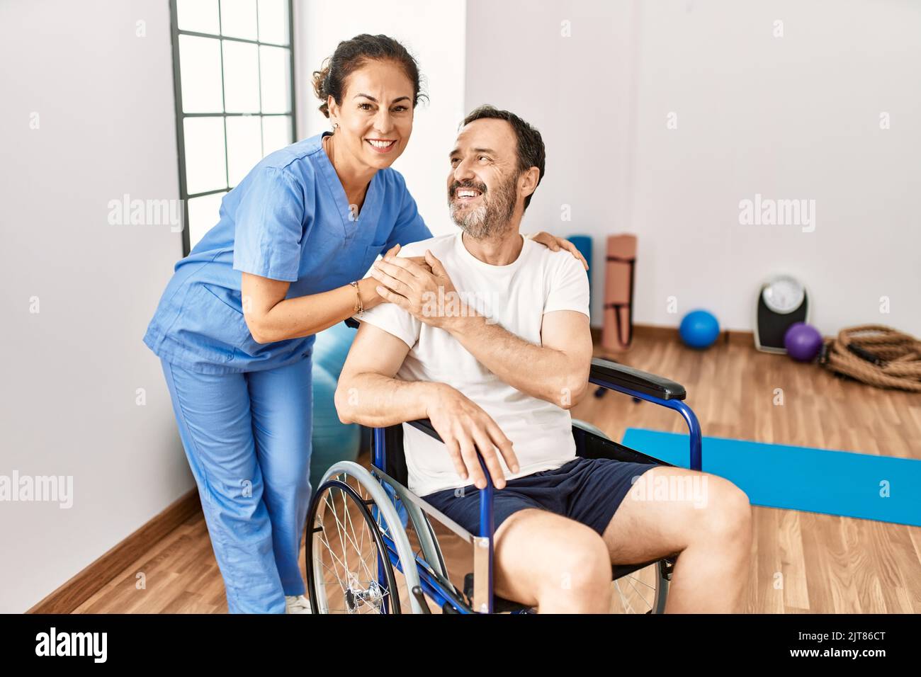 Middle age man and woman smiling confident having physiotherapy session ...