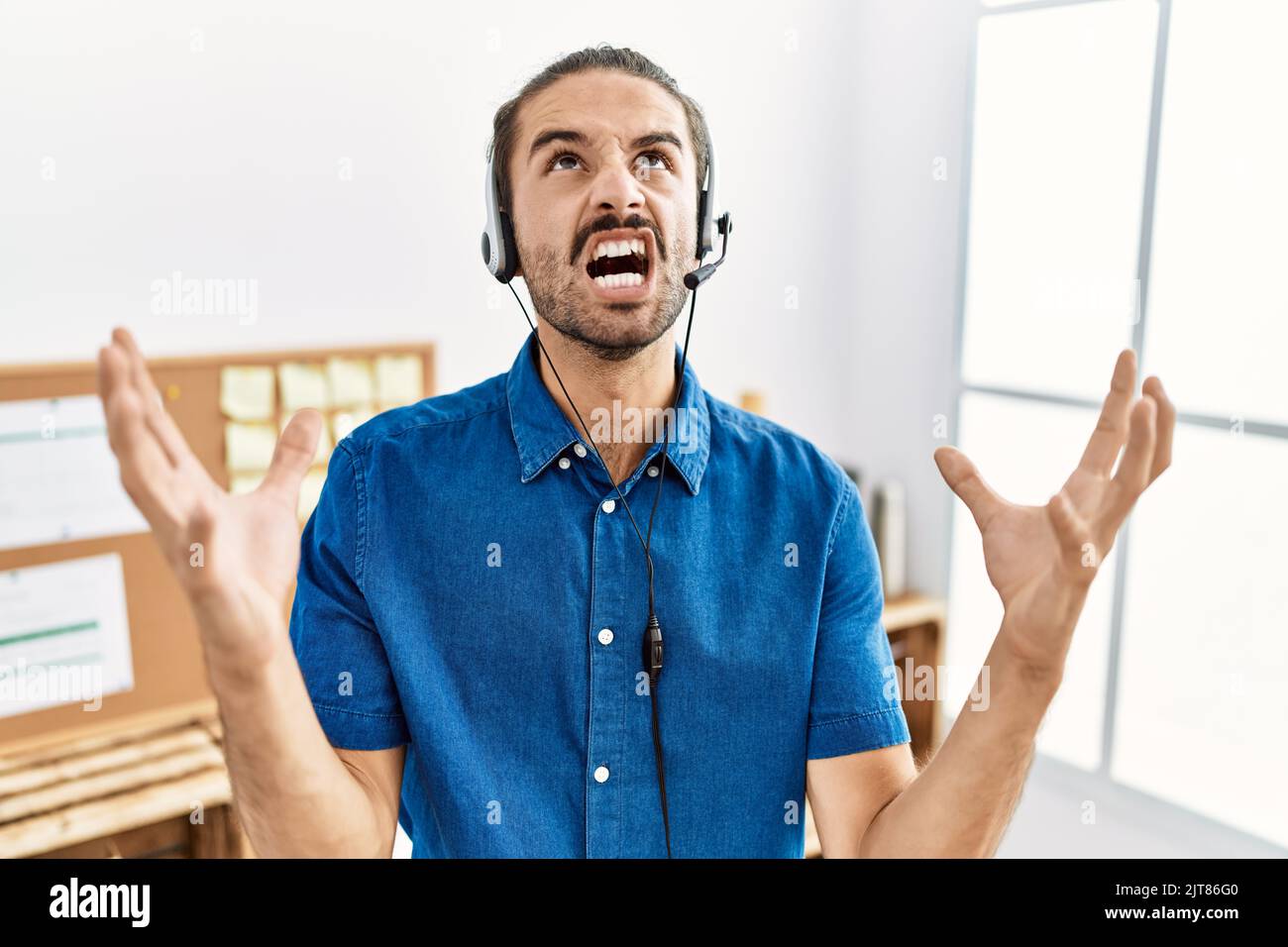 Young hispanic man with beard wearing call center agent headset at the ...