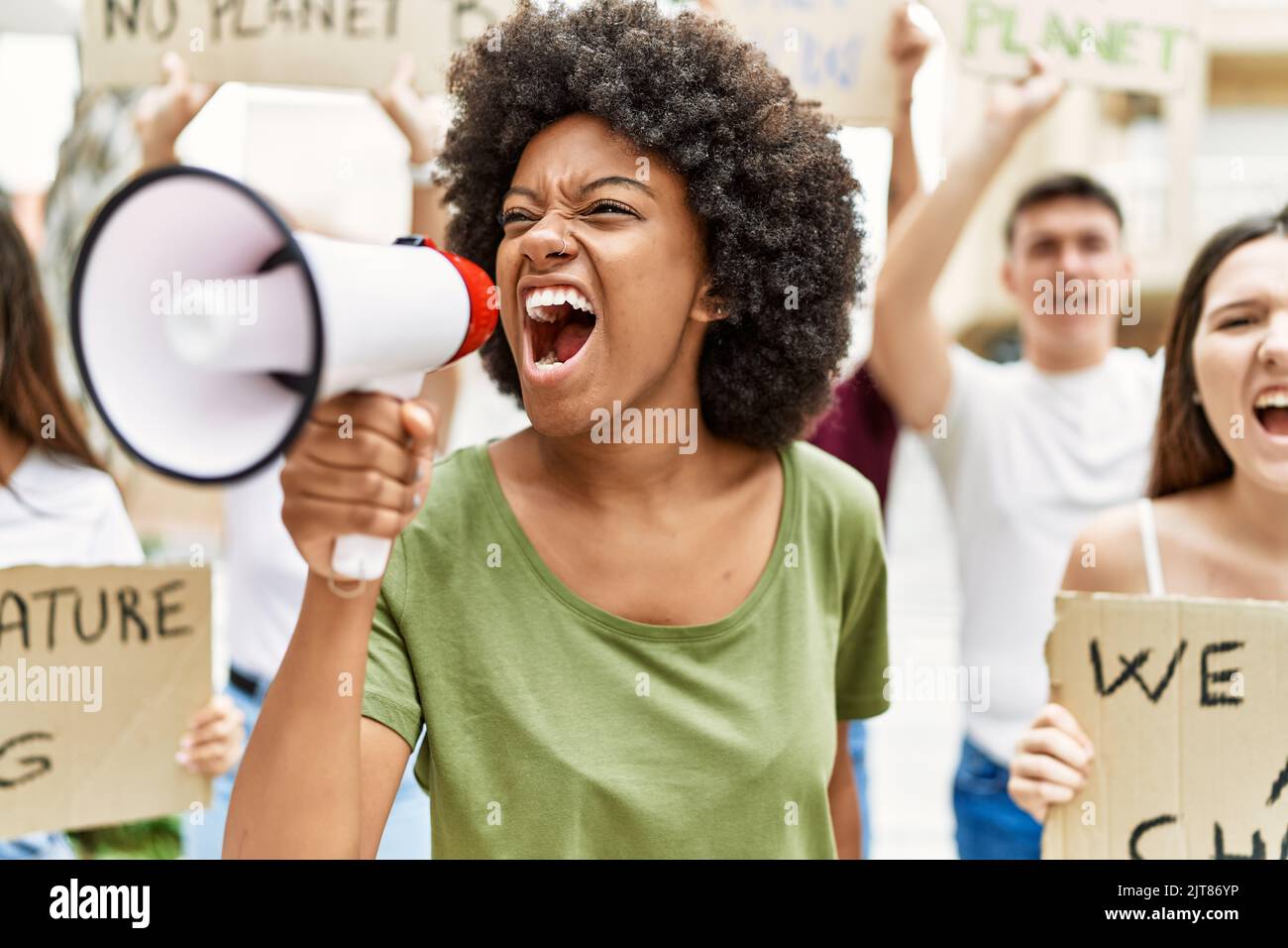 Group of young activists people protesting holding banner and using ...