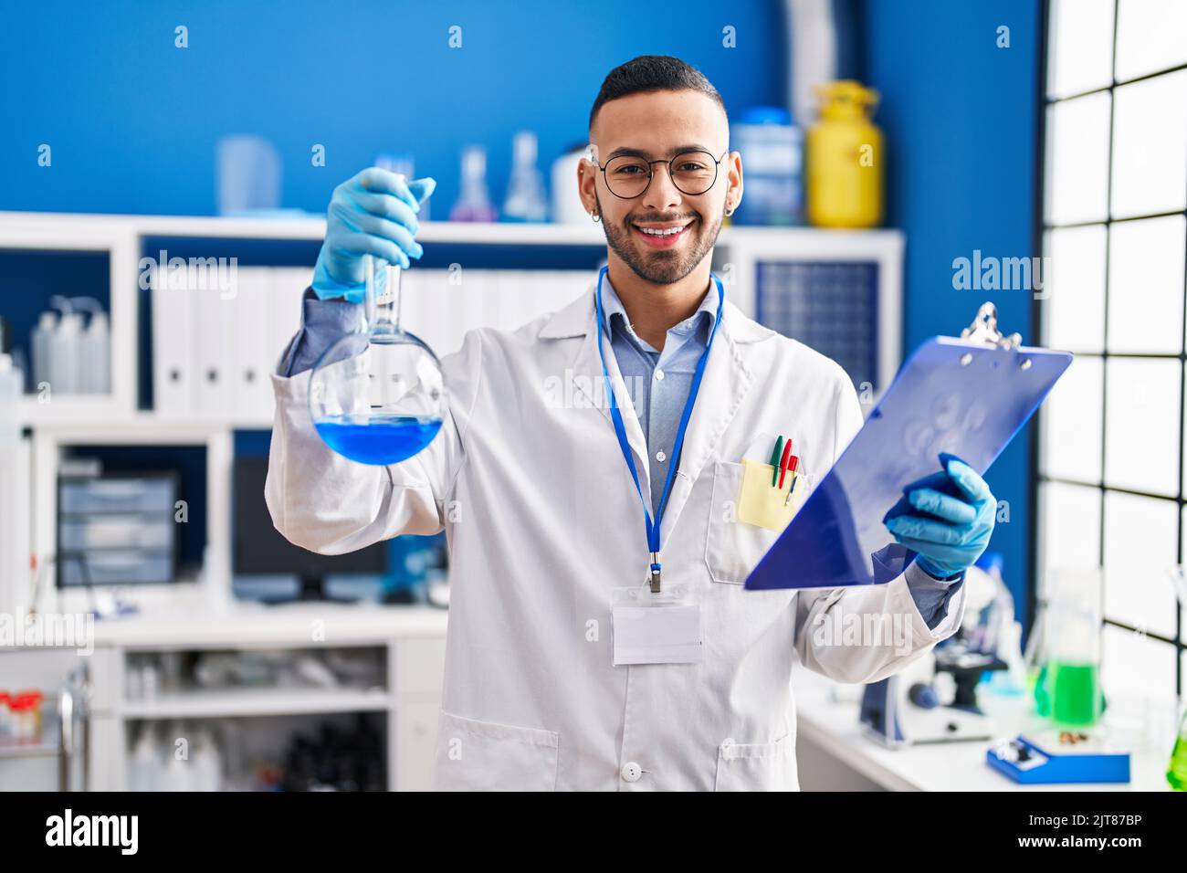 African american man scientist holding test tube reading document at ...