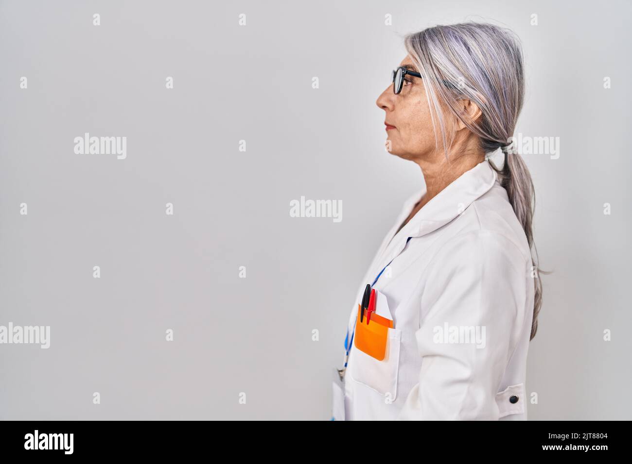 Middle age woman with grey hair wearing scientist robe looking to side ...