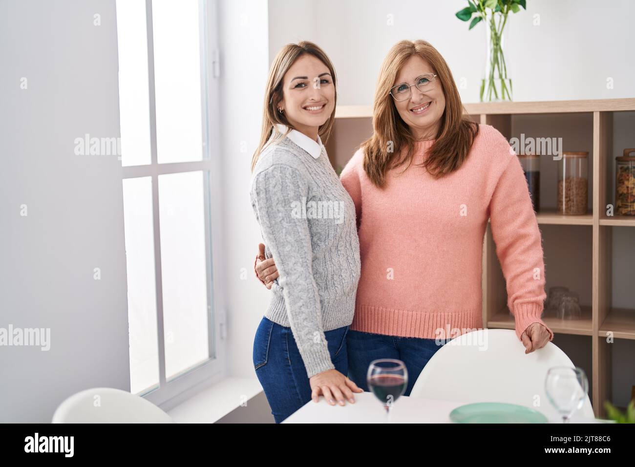 Mother and daughter hugging each other standing at home Stock Photo - Alamy