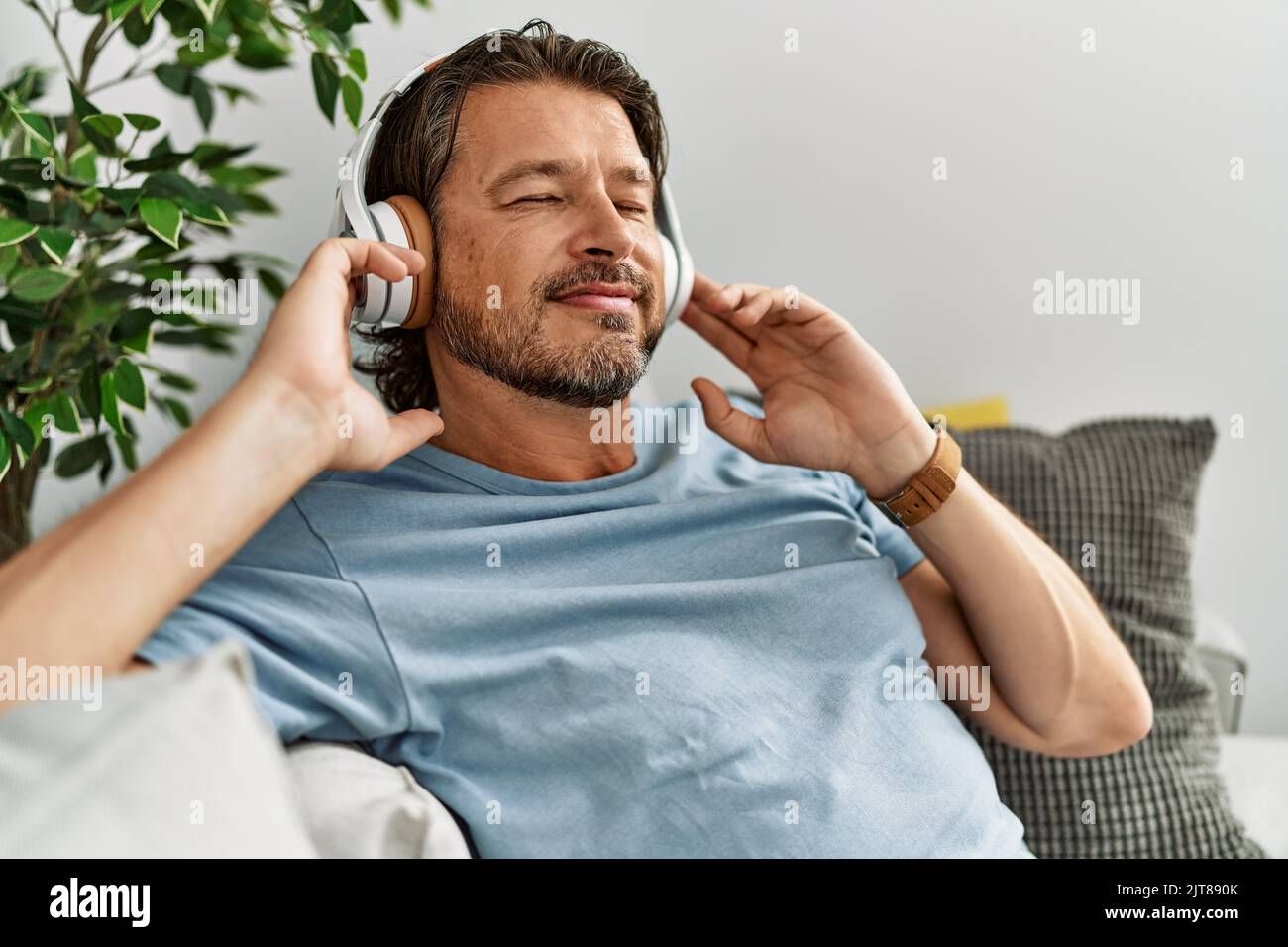 Middle age caucasian man smiling confident listening to music at home ...