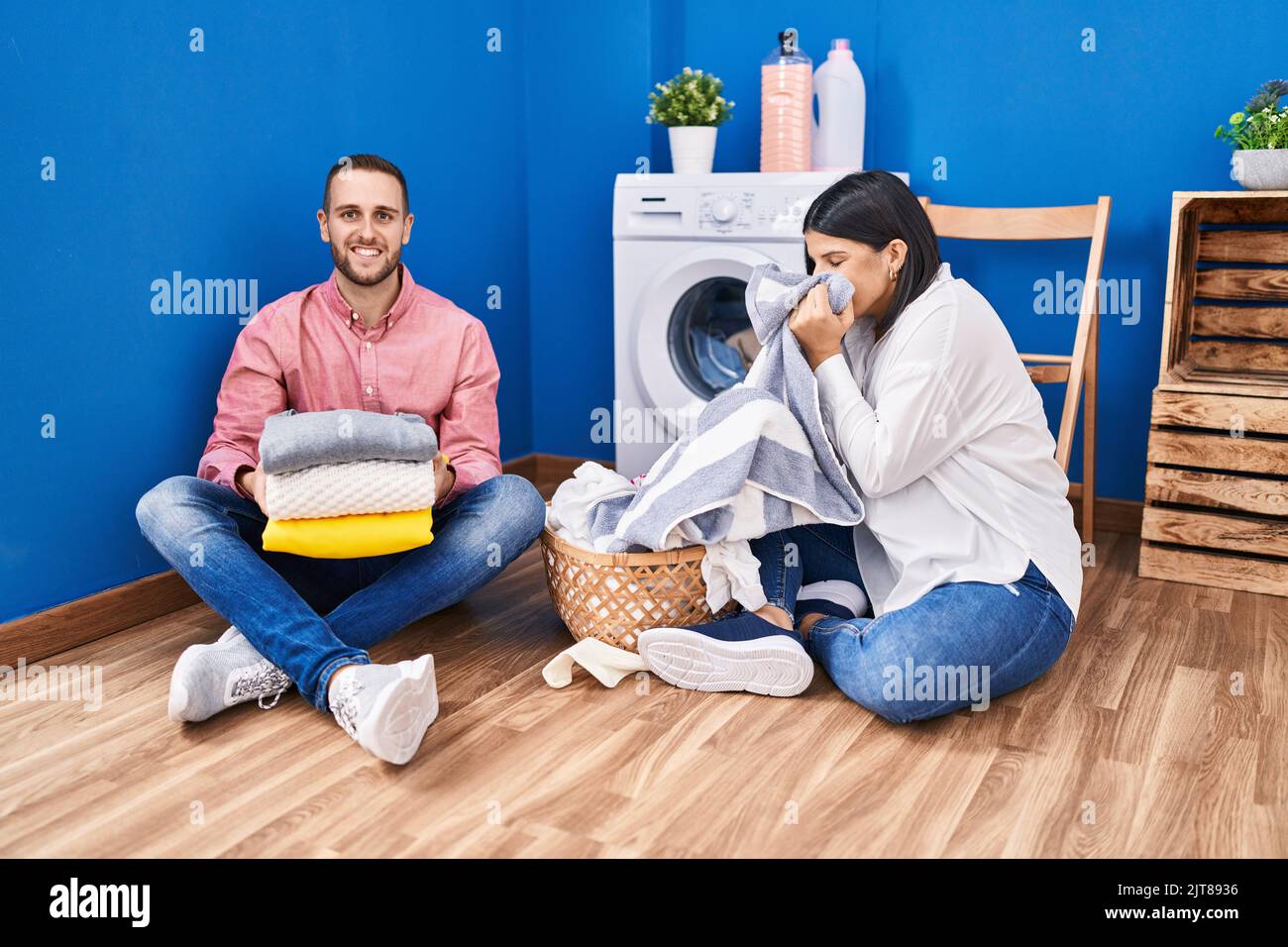 Man and woman couple washing and smelling clothes at laundry room Stock Photo - Alamy