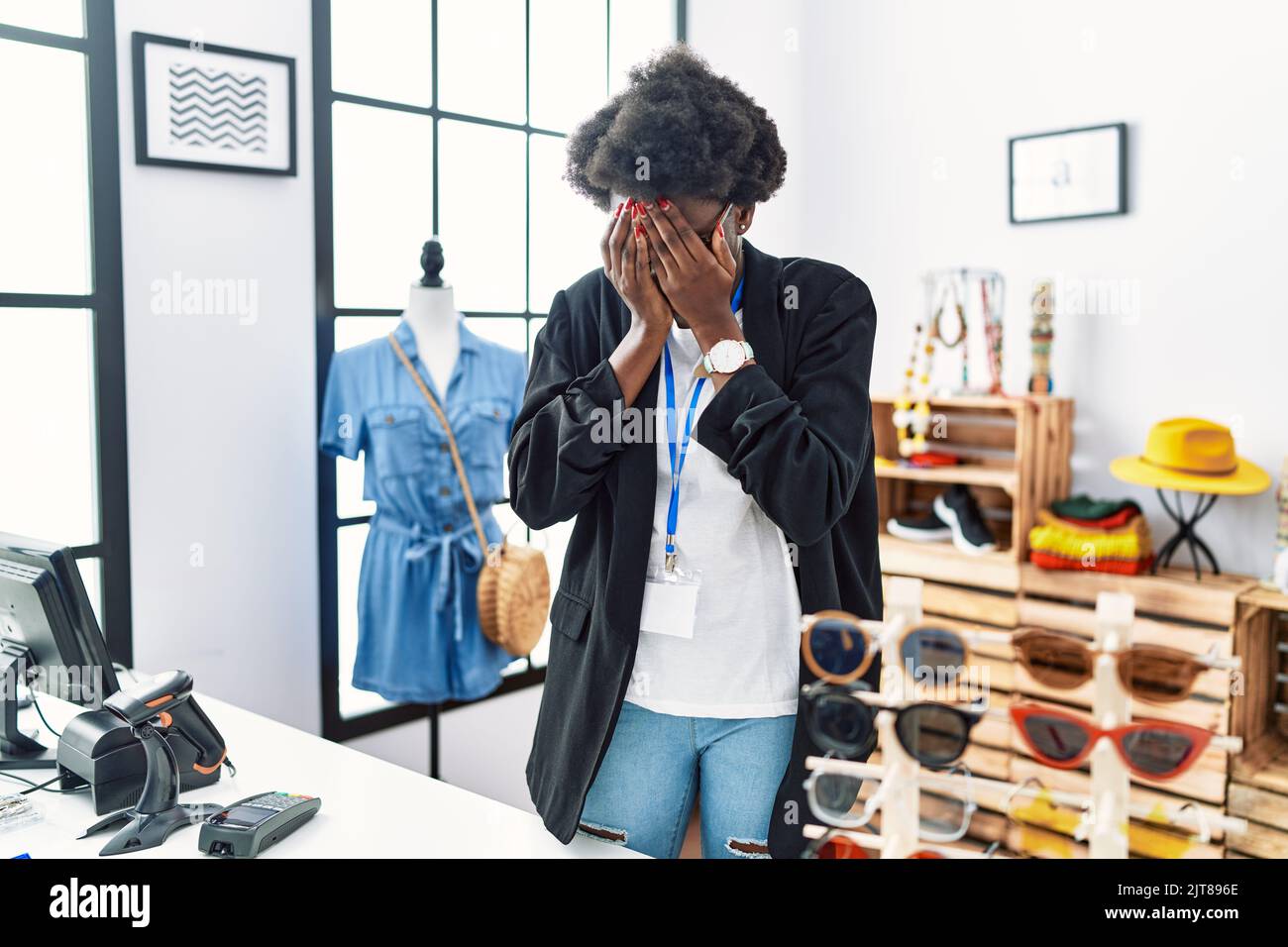 African young woman working as manager at retail boutique with sad ...