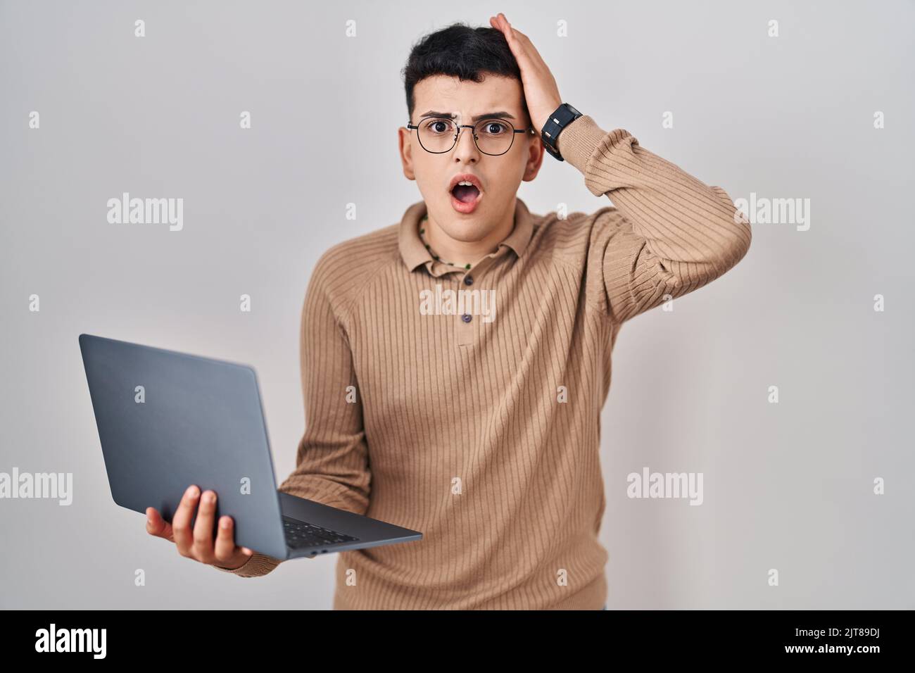 Non binary person using computer laptop crazy and scared with hands on ...