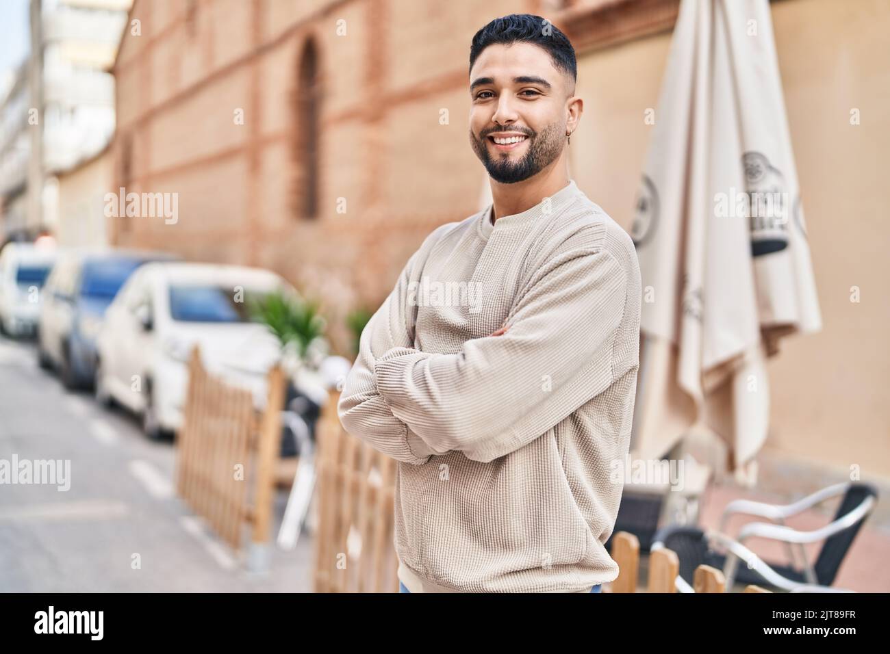 Young arab man smiling confident standing with arms crossed gesture at ...
