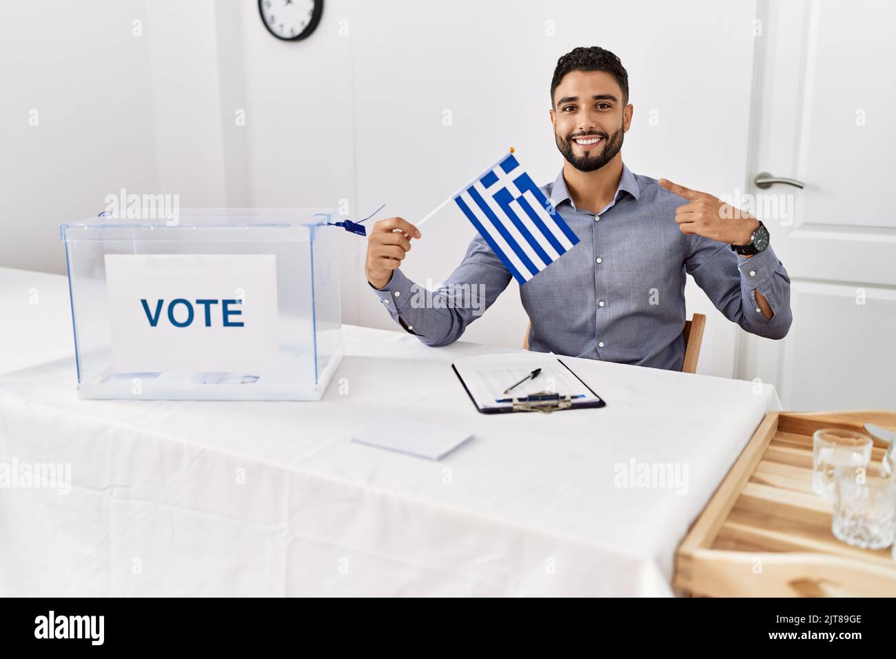 Young handsome man with beard at political campaign election holding ...