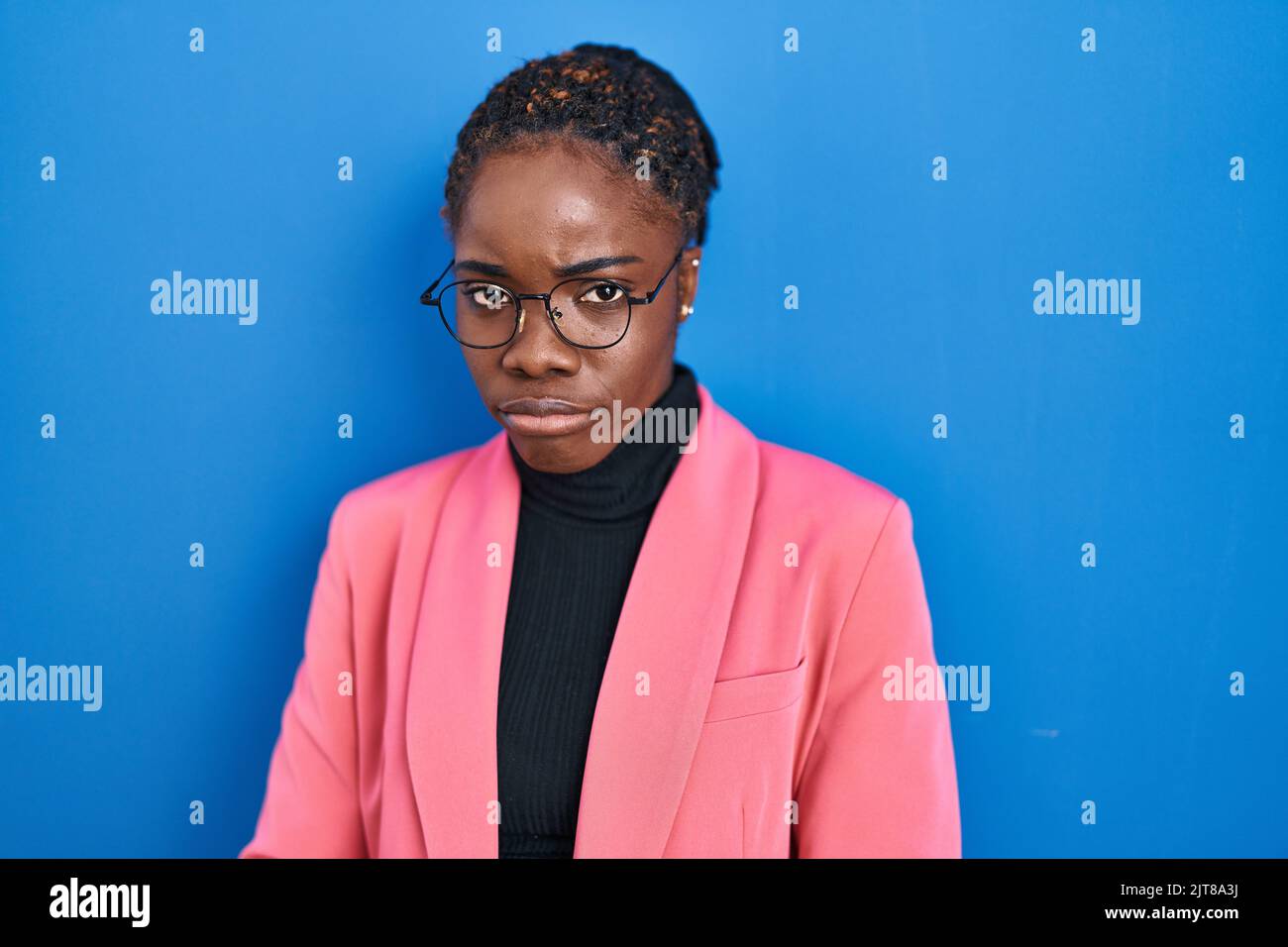 Beautiful Black Woman Standing Over Blue Background Depressed And Worry