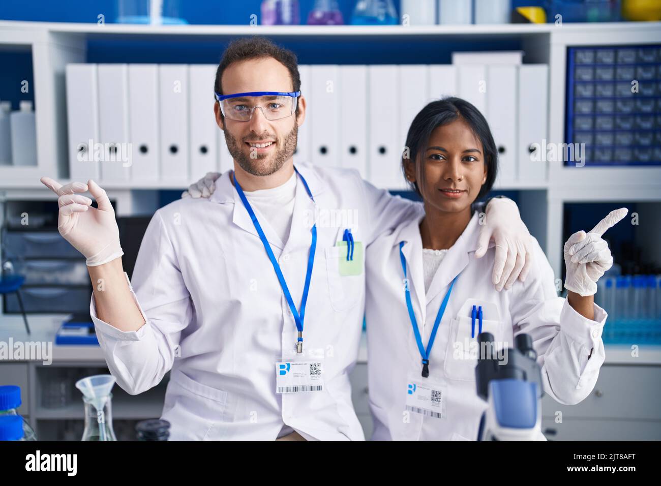 Interracial couple working at scientist laboratory smiling happy ...