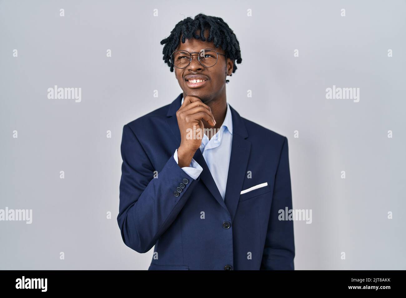 Young african man with dreadlocks wearing business jacket over white ...