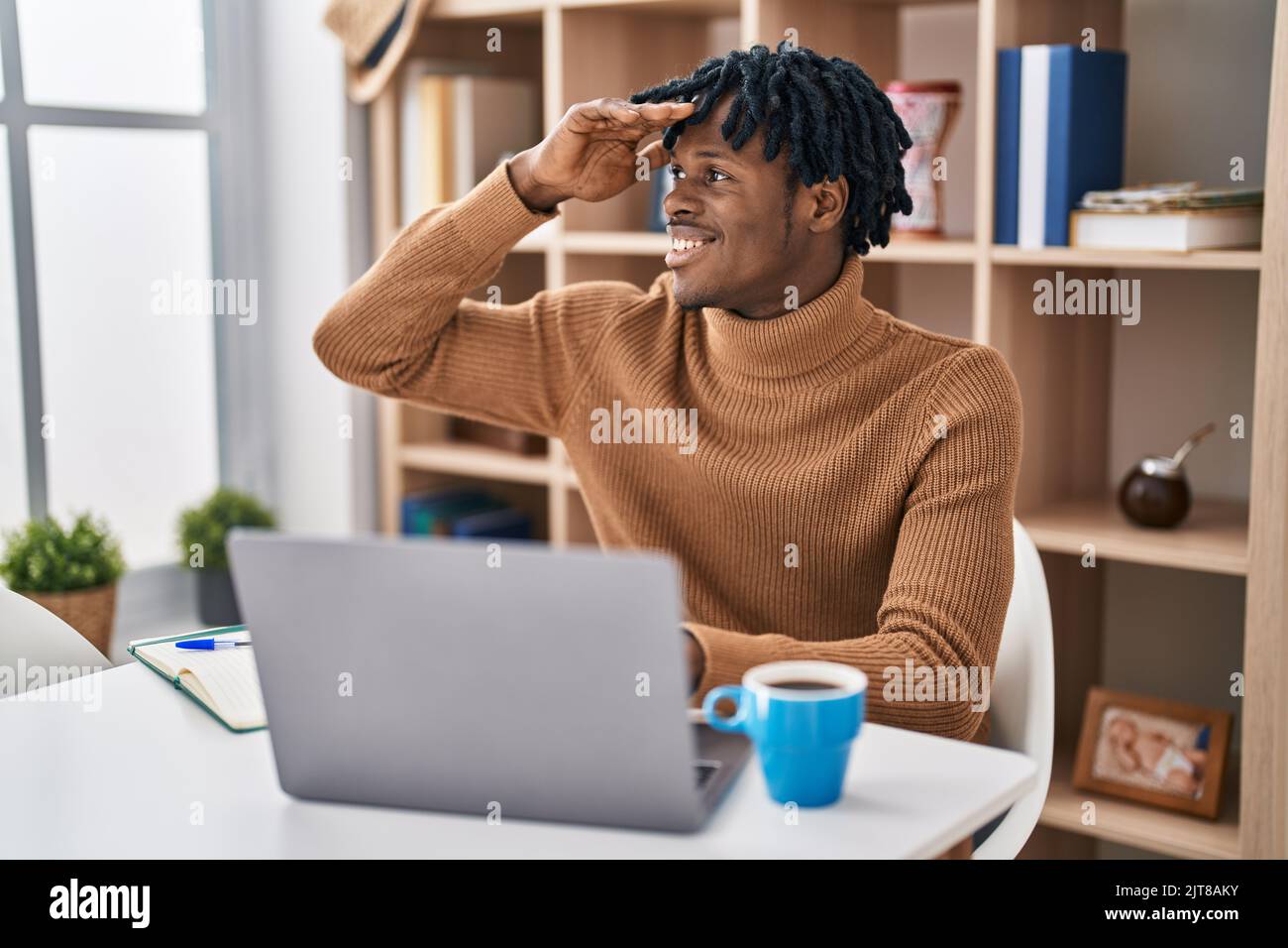 Young african man with dreadlocks working using computer laptop very ...