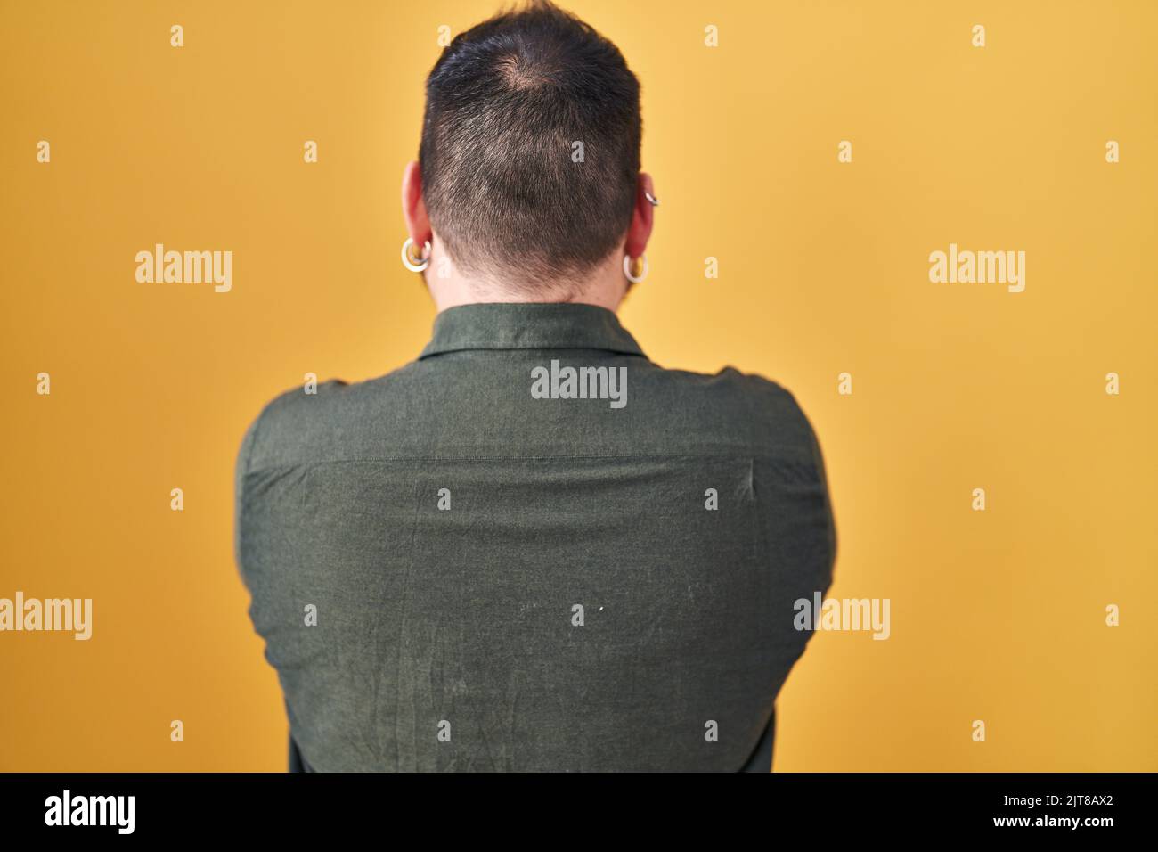 Plus size hispanic man with beard standing over yellow background ...