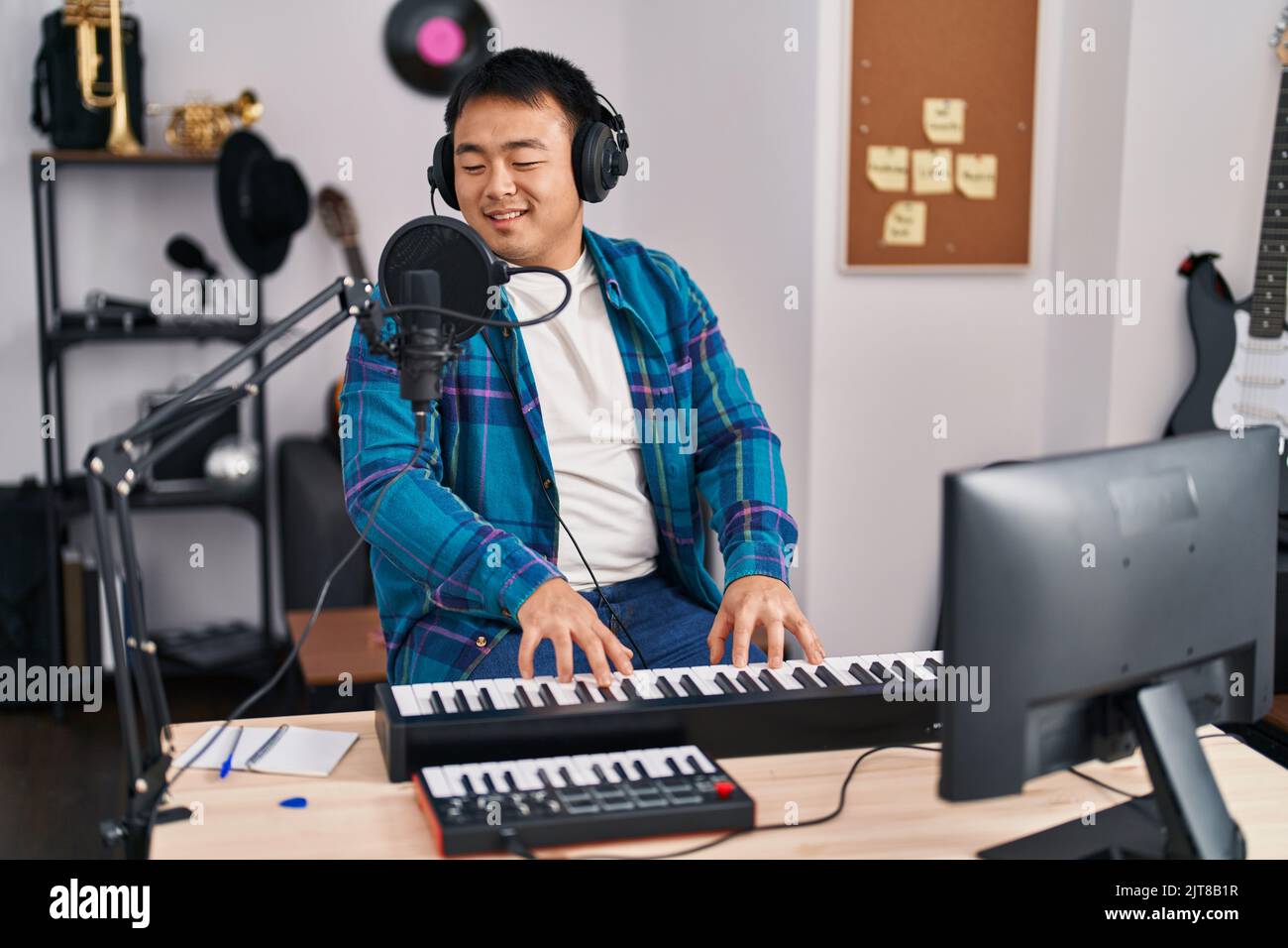Young chinese man singer singing song playing piano keyboard at music studio Stock Photo - Alamy