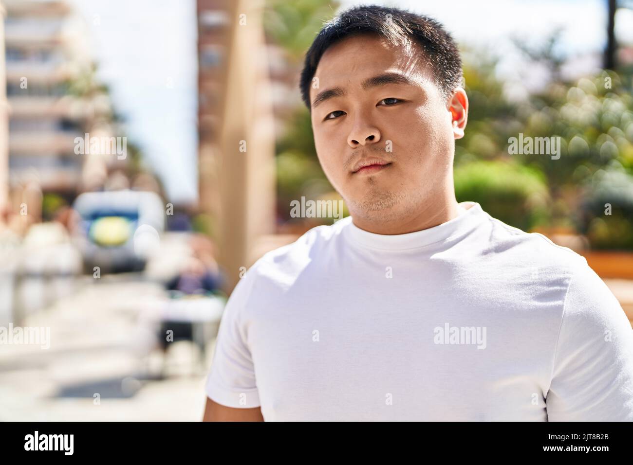 Young chinese man standing with relaxed expression at street Stock ...