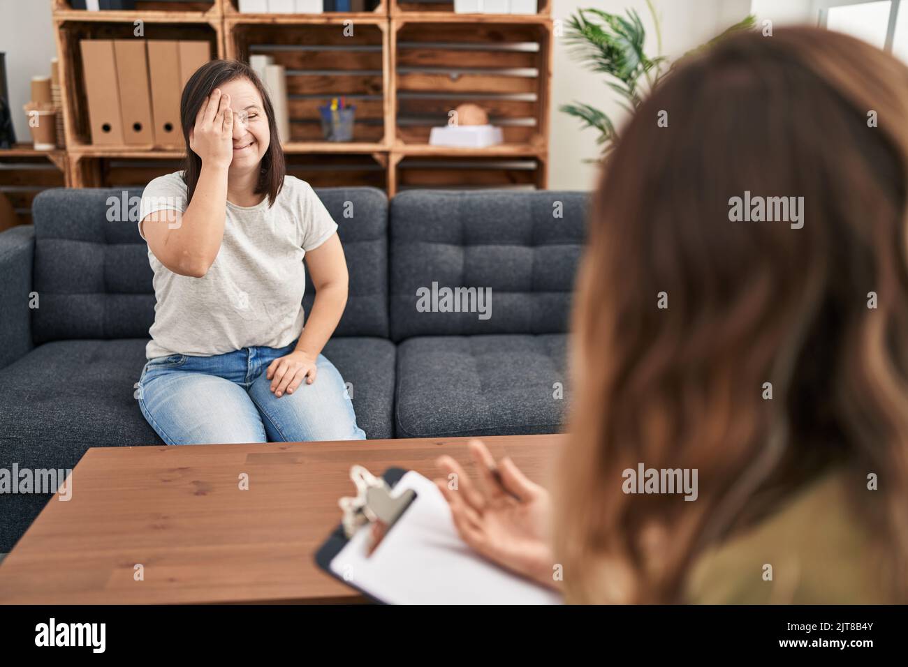 Hispanic girl with down syndrome doing therapy covering one eye with ...