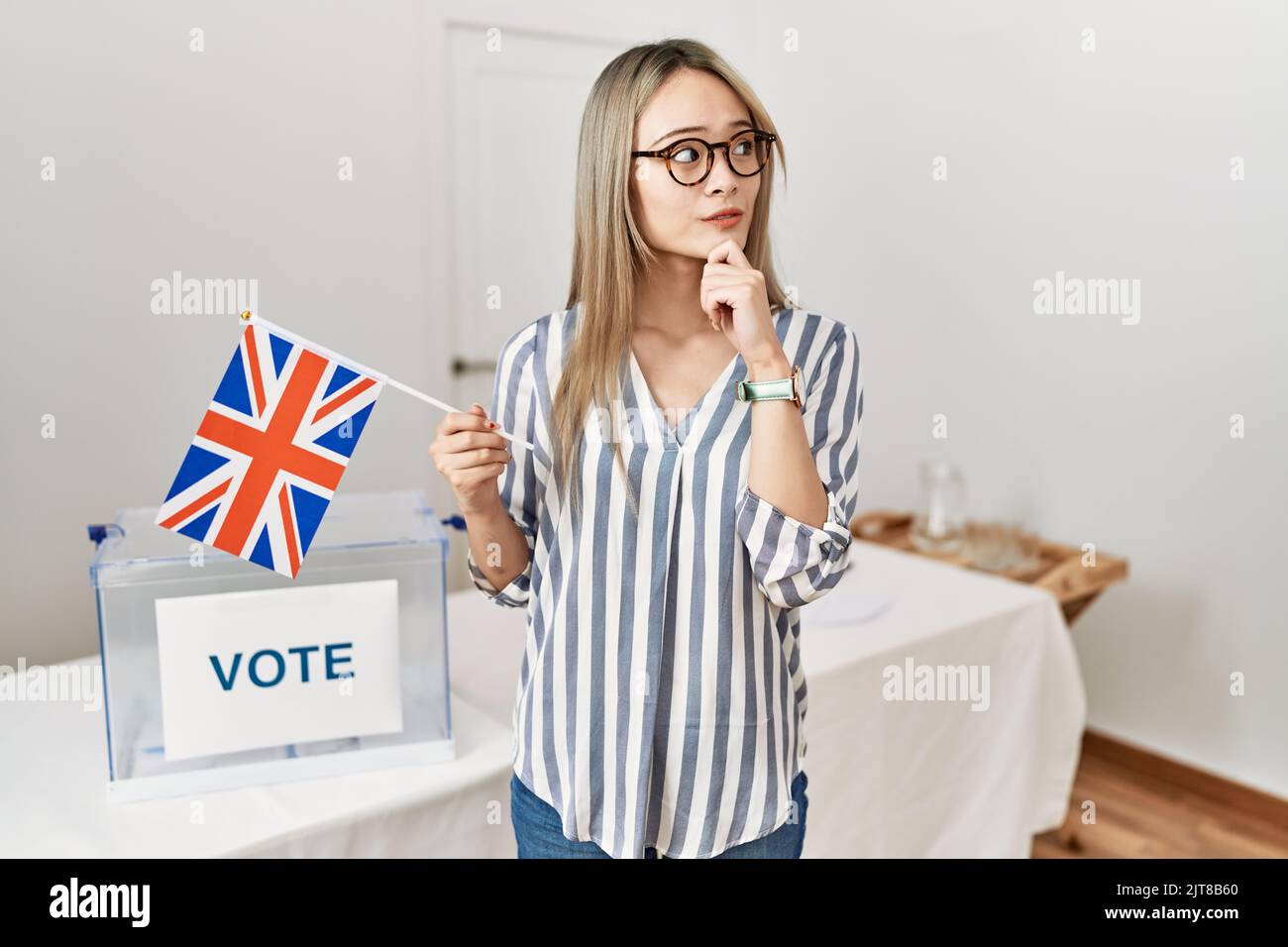 Asian young woman at political campaign election holding uk flag ...