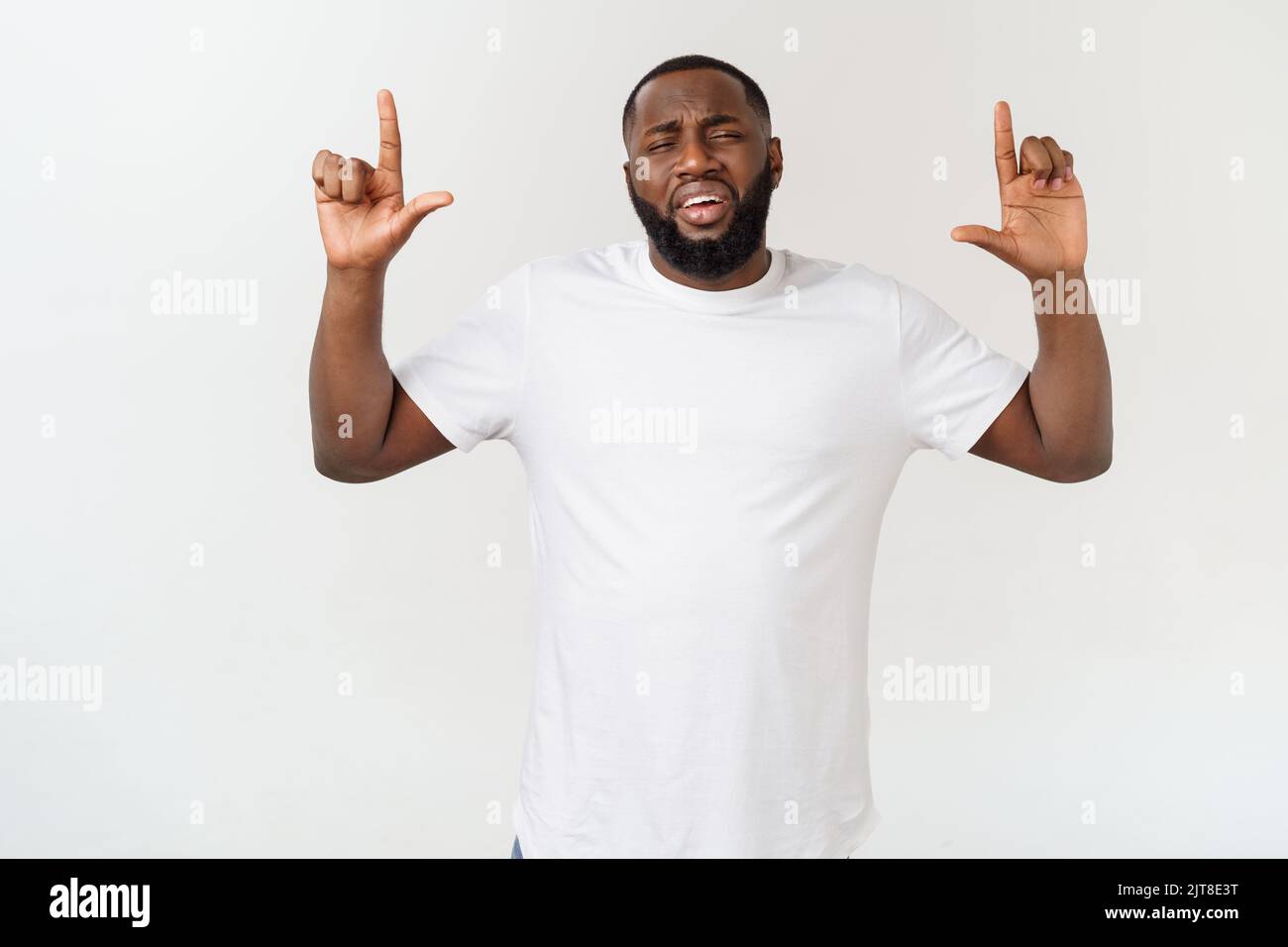 Young amazed African American pointing his finger at white background ...