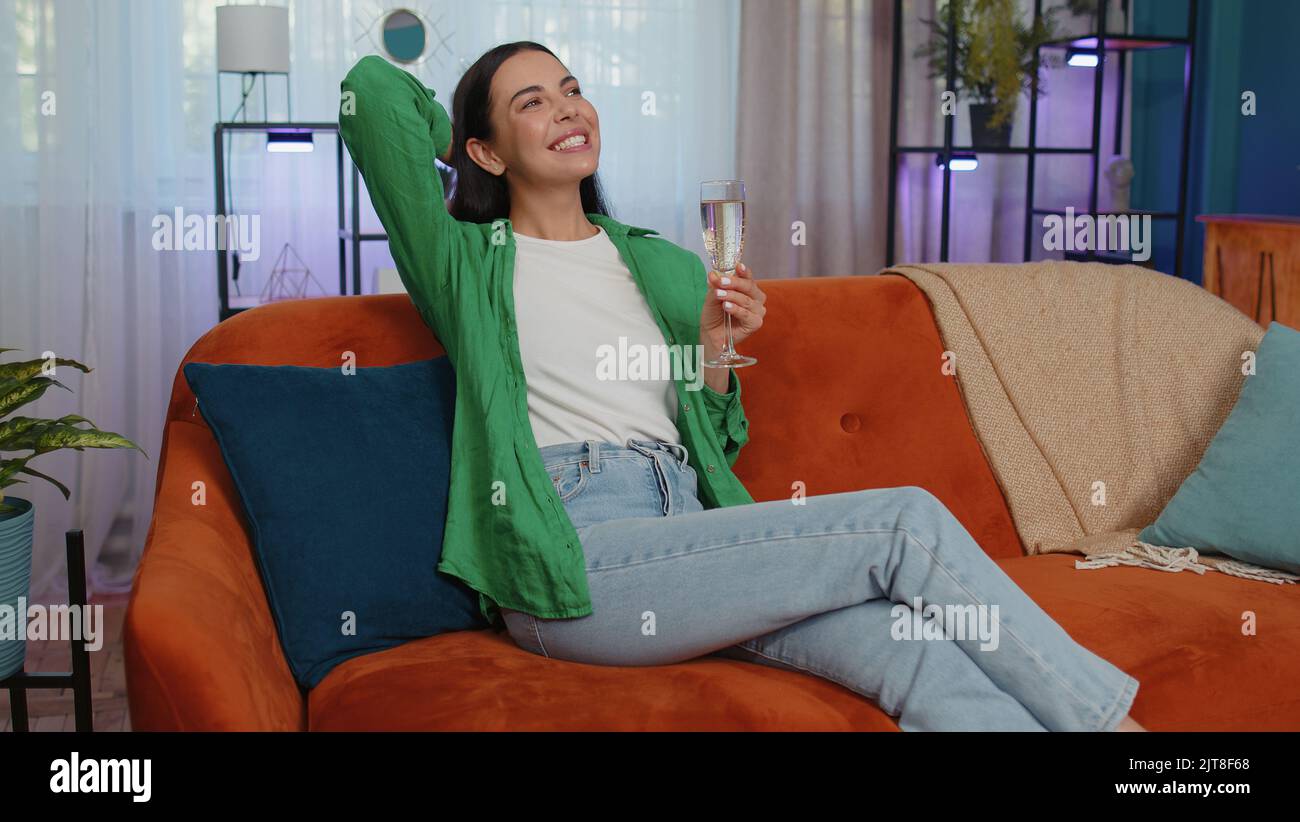 Joyful caucasian girl hold glass of champagne cheering drinking ...