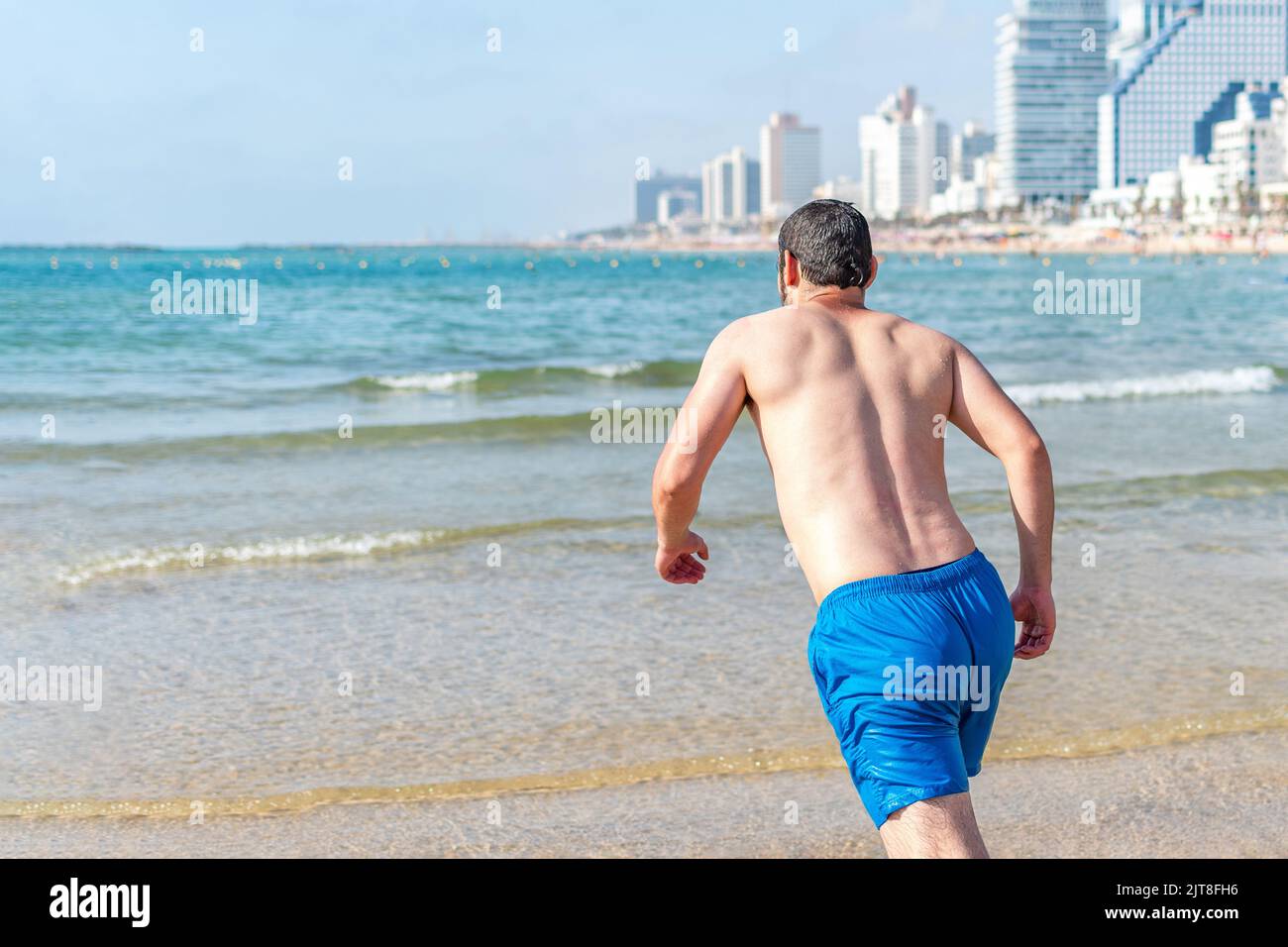 A man running into the beach during summer Stock Photo - Alamy