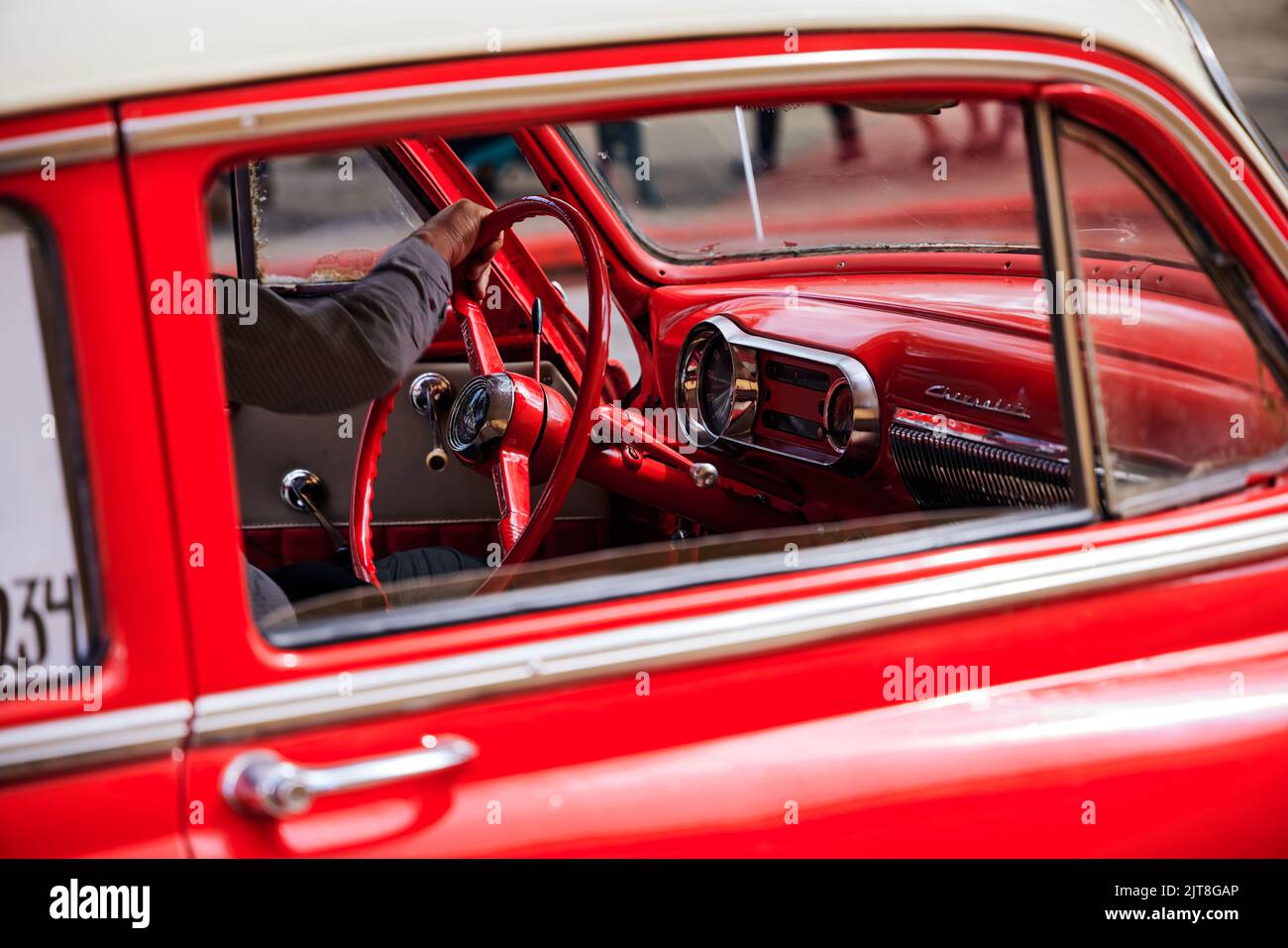 A closeup of a classic red car cockpit with a man hand on it in Mexico ...