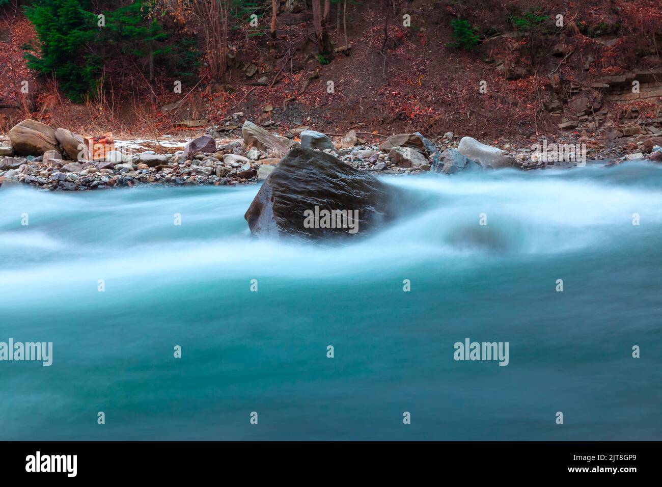 Natural rock in flowing water . Nature long exposure shot . Big stone ...