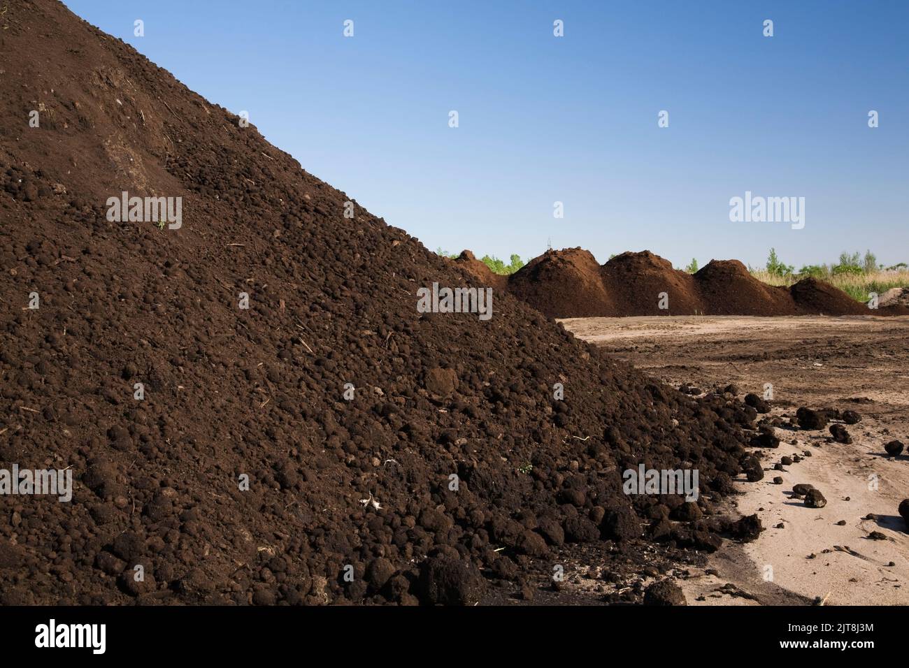 Mounds of dark brown topsoil in a commercial sandpit Stock Photo - Alamy