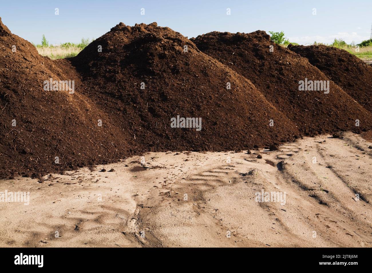 Mounds of dark brown topsoil in a commercial sandpit Stock Photo - Alamy