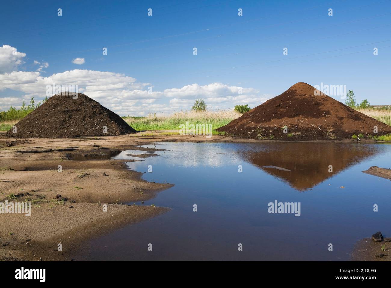 Mounds of tree bark shavings and brown topsoil after a heavy rainfall ...