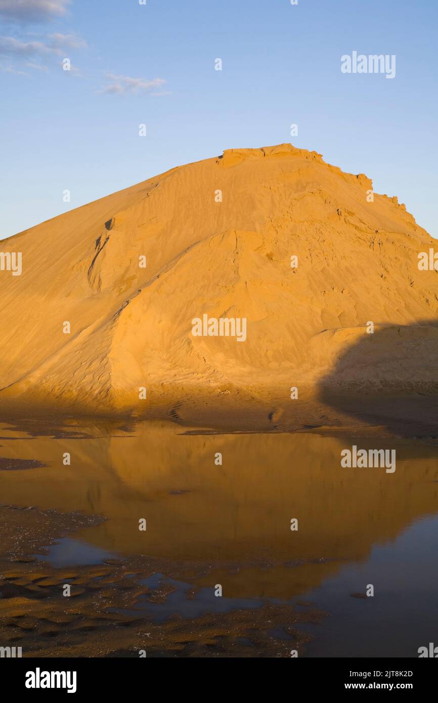 Mound of golden brown sand in a commercial sandpit after a heavy ...