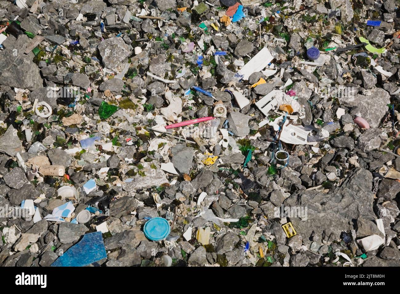 Discarded plastic, glass and other debris on ground at waste management ...