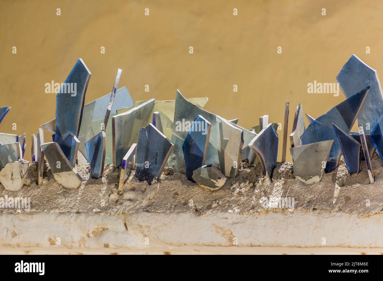 Wall topped with sharp shards for the protection against intruders ...