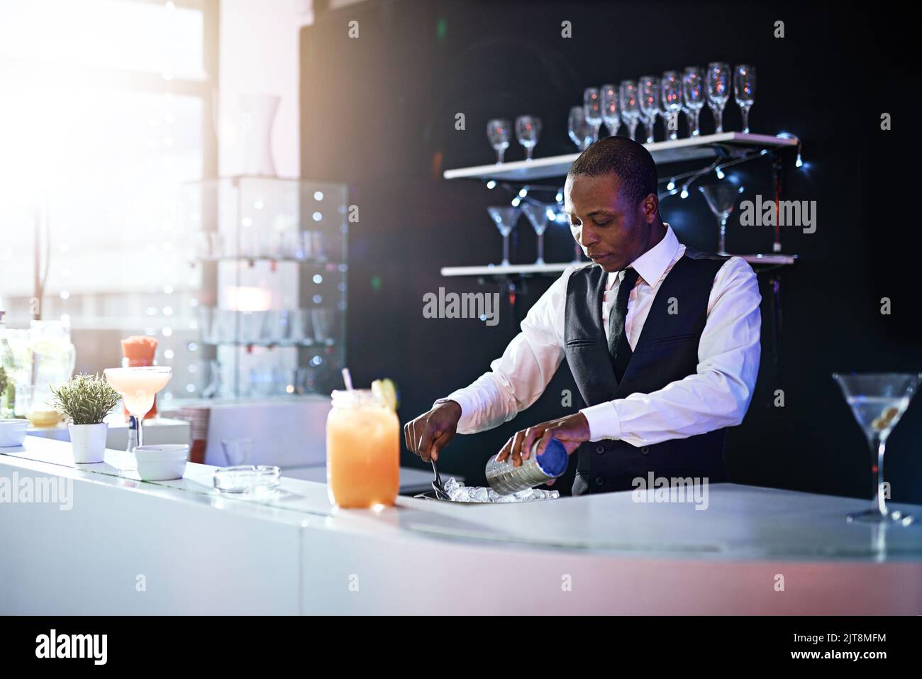 Just name the drink. a well-dressed bartender standing behind the ...